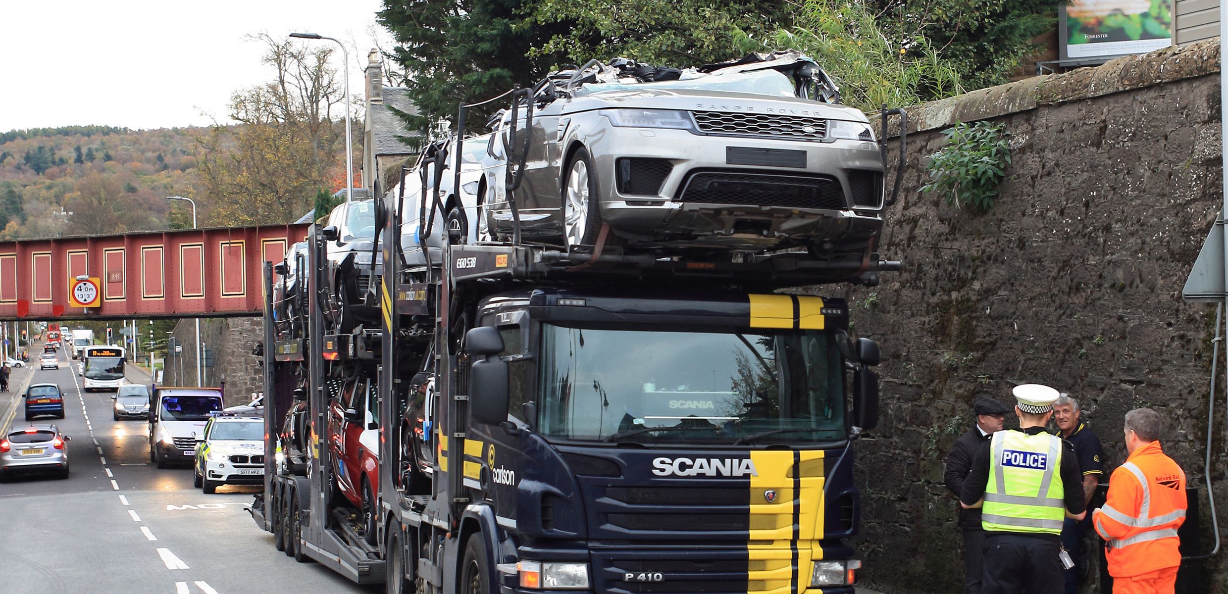 Range Rover transporter takes tops off new trucks driving under bridge ...