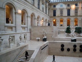 An employee walks inside the Musee du Louvre in Paris, while it was closed to the public during the first wave of COVID-19 on March 13, 2020.