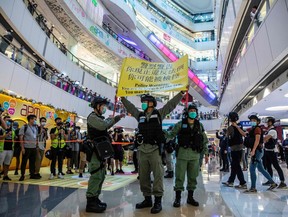 Riot police hold up a warning flag during a demonstration in a mall in Hong Kong on July 6, 2020.