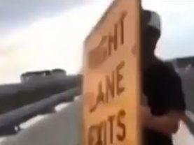 Cops probing video of giant sign tossed onto QEW | Toronto Sun